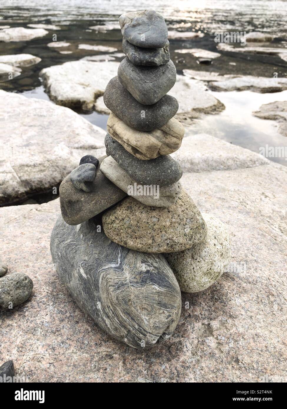 Stacked rocks on the edge of a river Stock Photo - Alamy