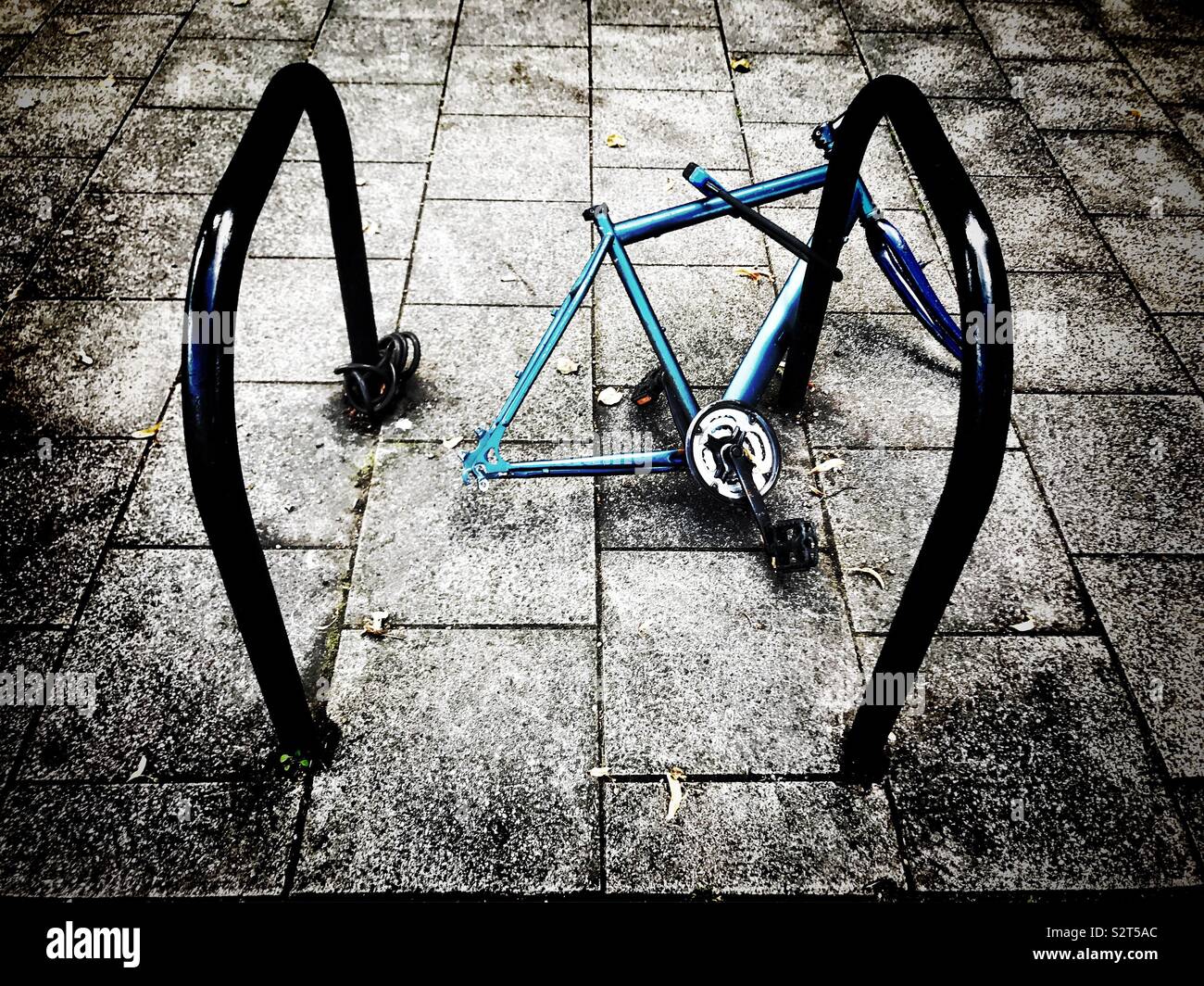 The frame of a bike is left chained to a post after the wheels have ...