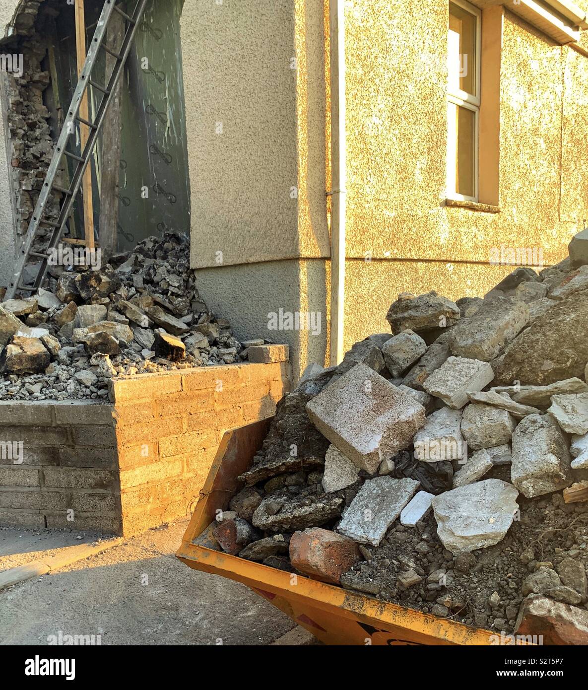 House renovation with hole in wall with skip full of rubble Stock Photo ...