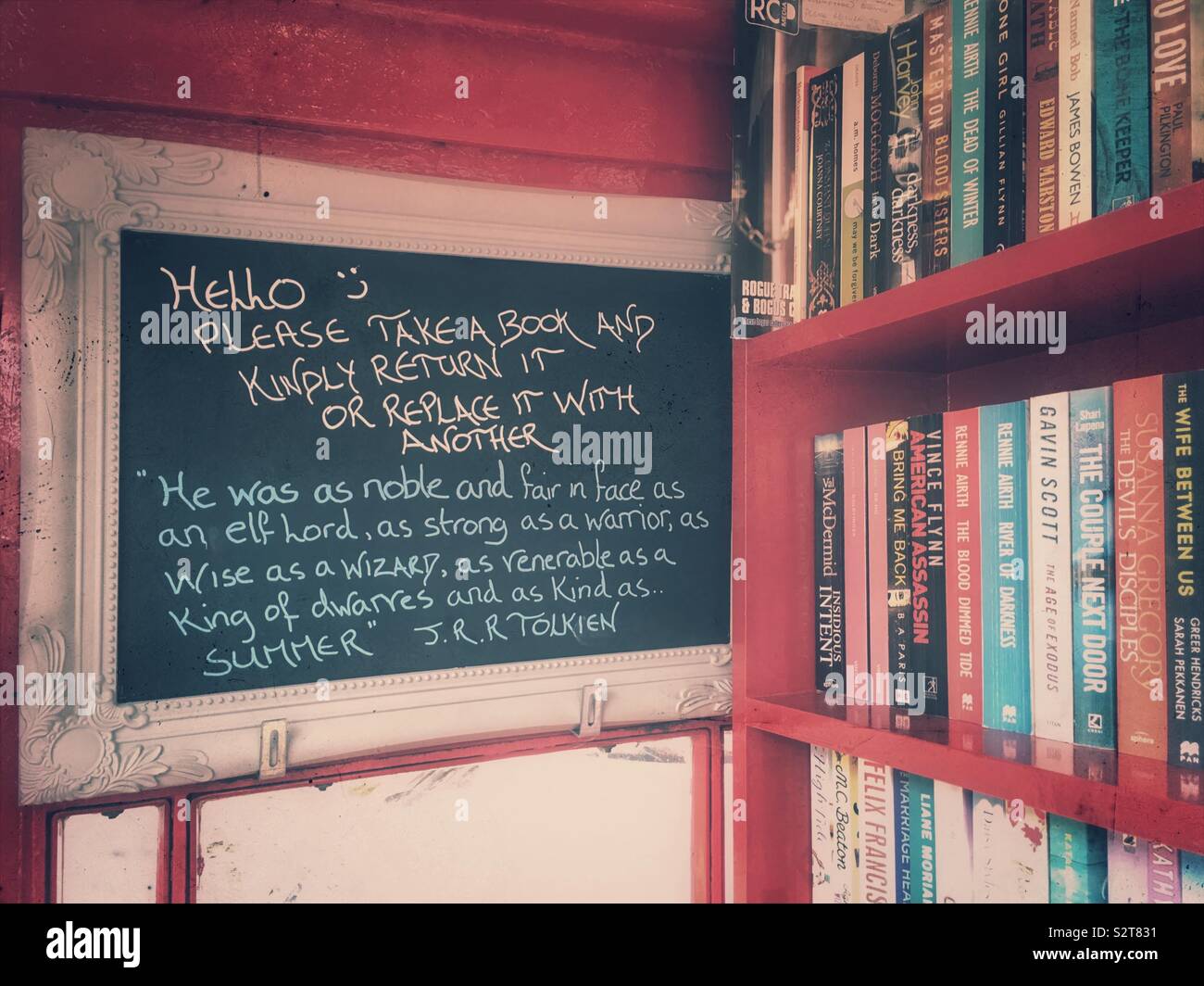 Old red public telephone box converted into a mini library, with a ...