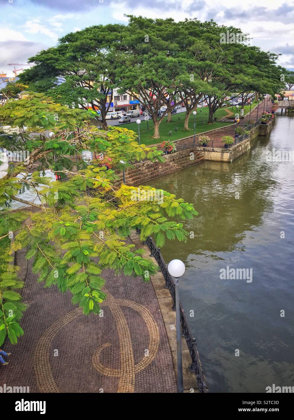 Trees provide shade along the Waterfront promenade, Kuching, Sarawak ...