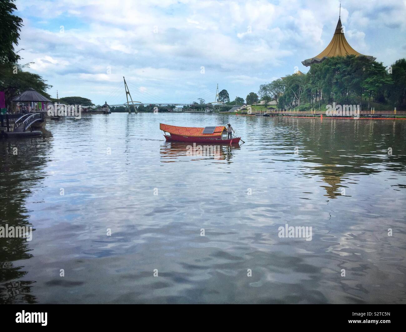 A traditional Malay sampan is used to ferry people across the Sarawak ...