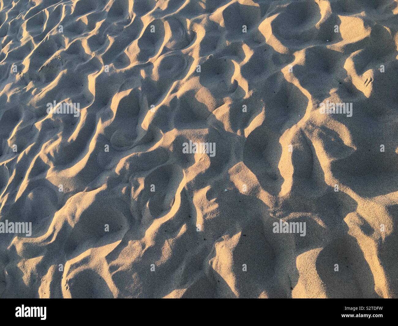 Sandy beach texture with strong sunlight from side Stock Photo - Alamy