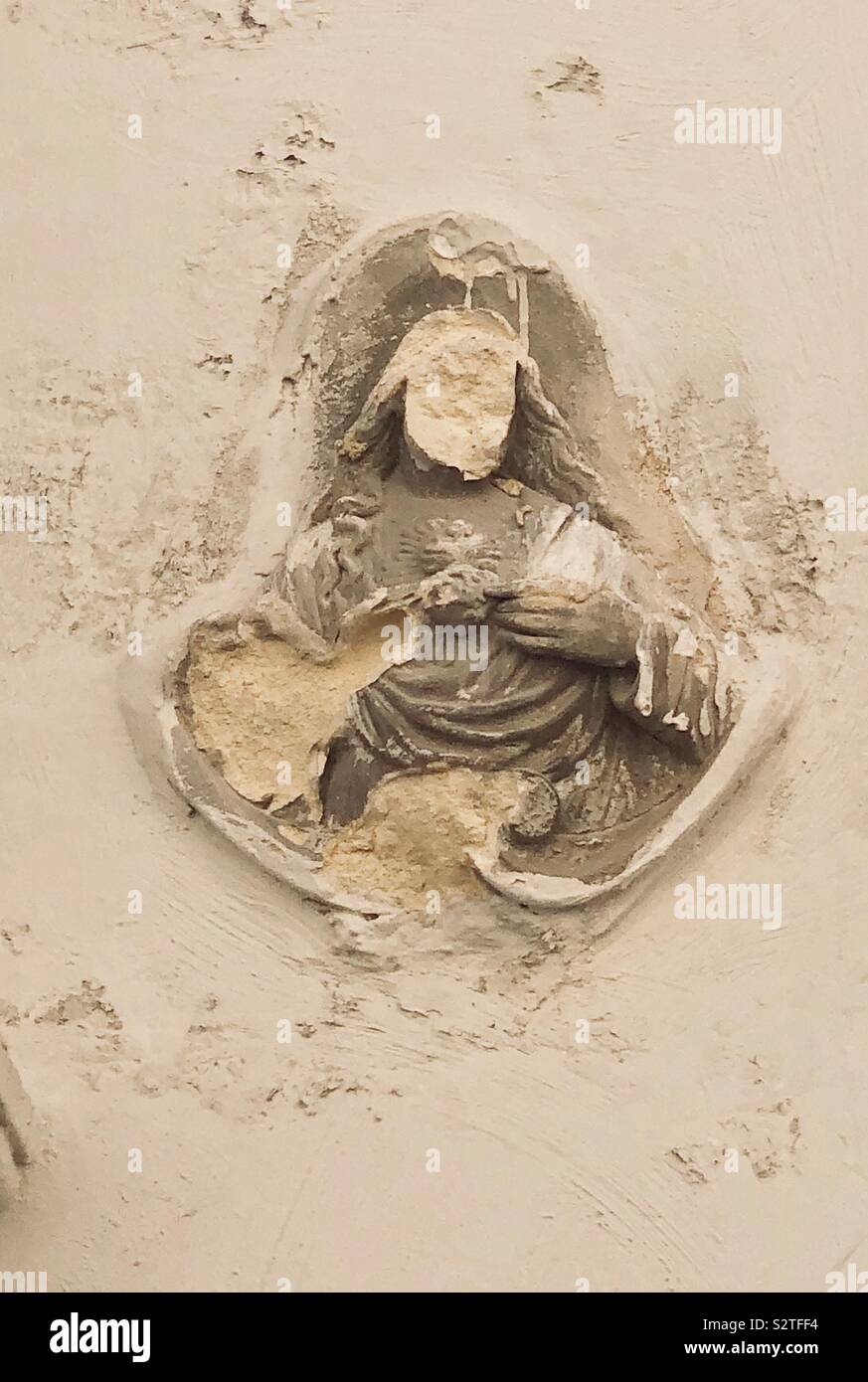 Damaged eroded religious figure set in a Maltese facade Stock Photo - Alamy