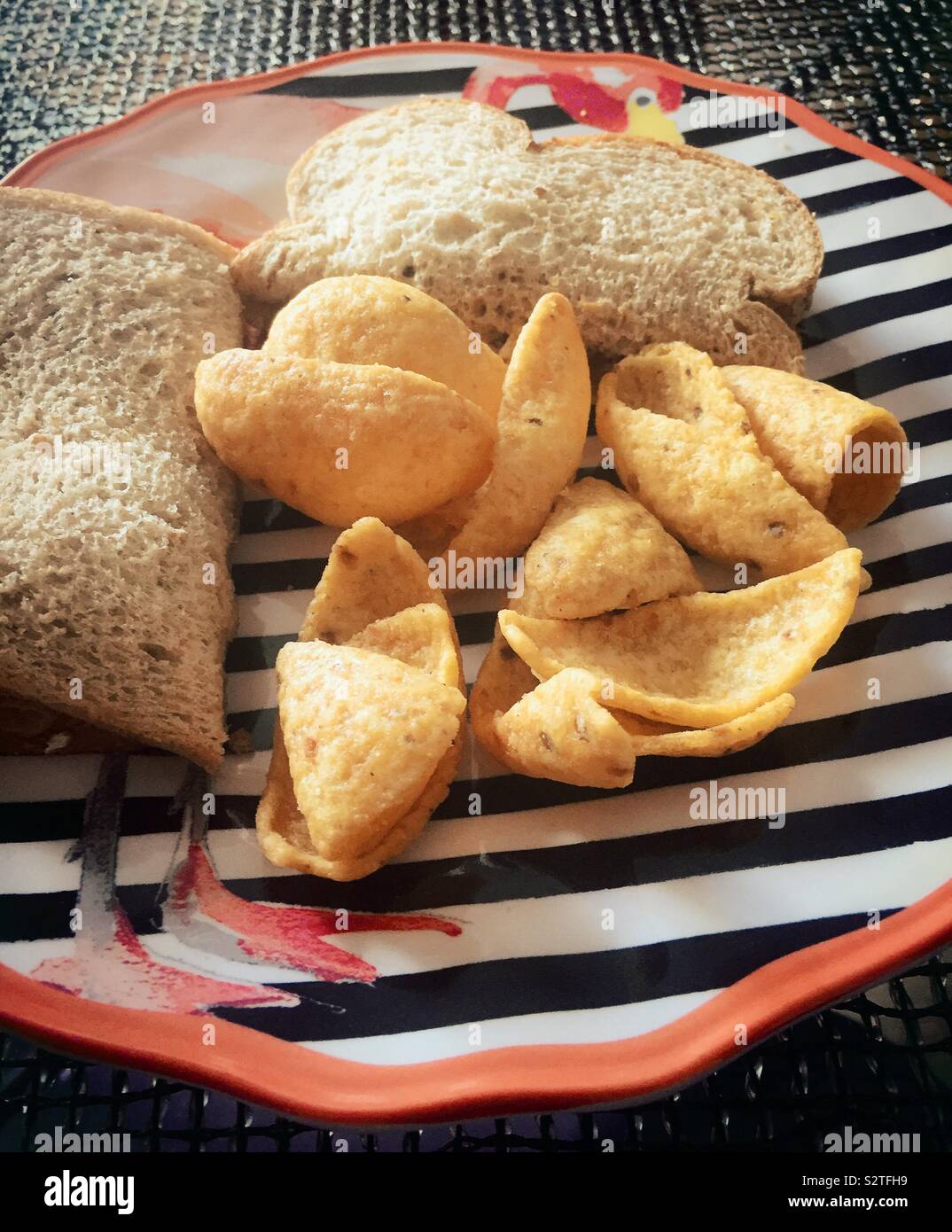 A lunchtime sandwich on whole wheat bread and Fritos corn chips on a ...