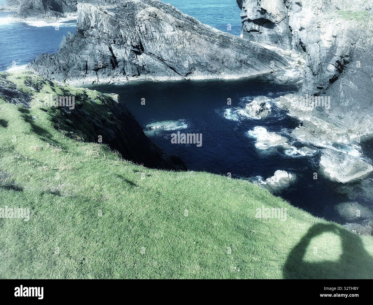 Shadow of photographer standing at top of dramatic cliffs, Butt of ...