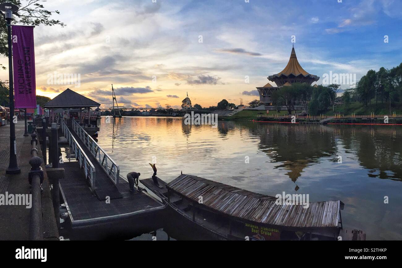 A boatman moors his traditional Malay Iban longboat, with a stylised ...