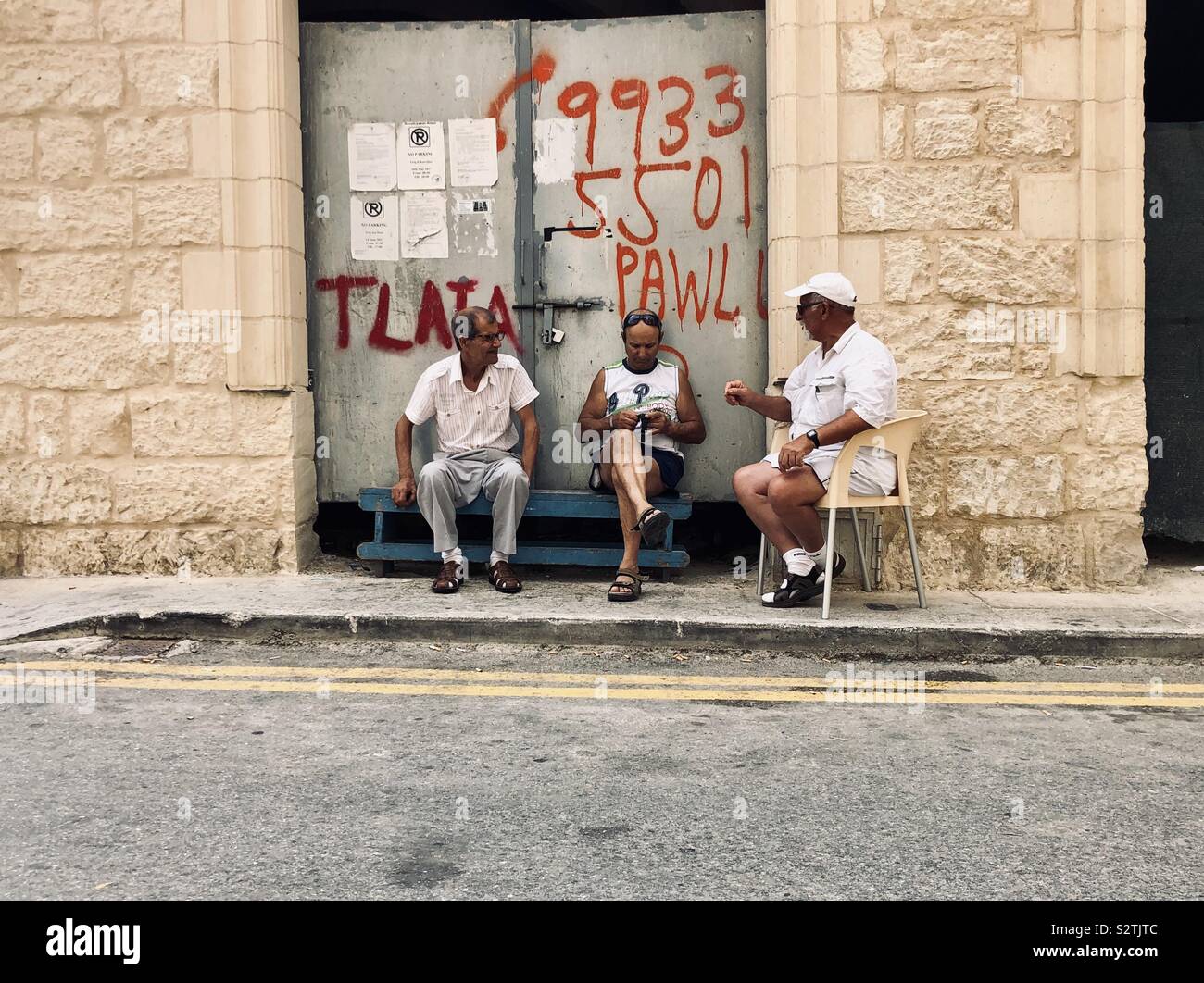 Three older men sitting on a street in medina Malta Stock Photo - Alamy