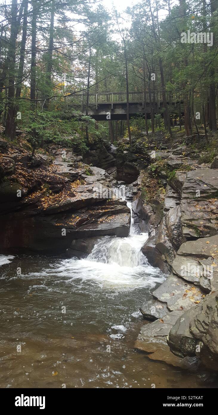 Waterfall under old bridge Stock Photo - Alamy