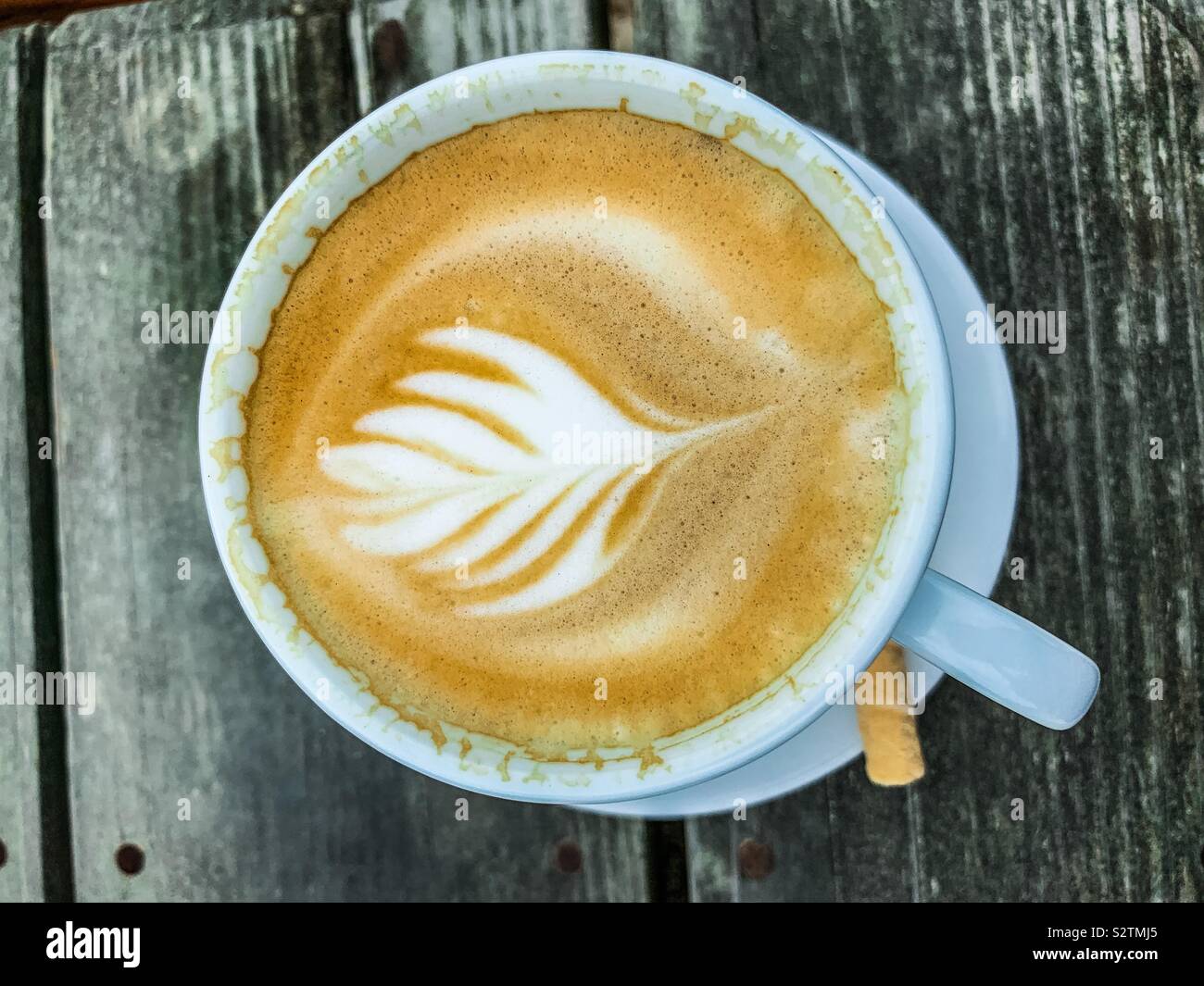 Cup of latte coffee on bench Stock Photo - Alamy