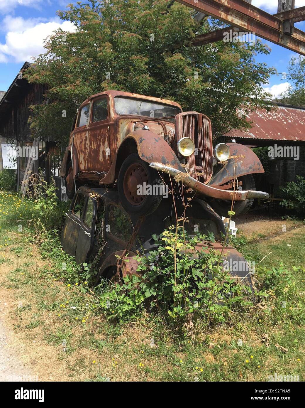 Rusty old French cars piled on top of each other. Below an old Light 15 ...