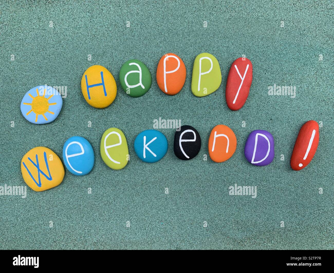 Happy Weekend text with colored stones over green sand Stock Photo - Alamy