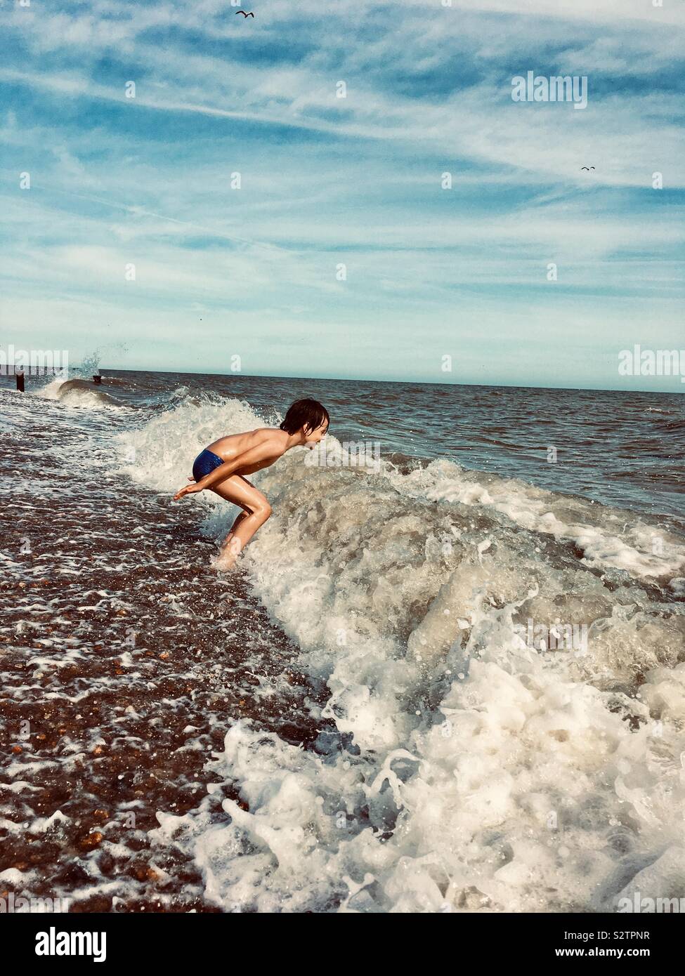 Boy against the waves Stock Photo - Alamy