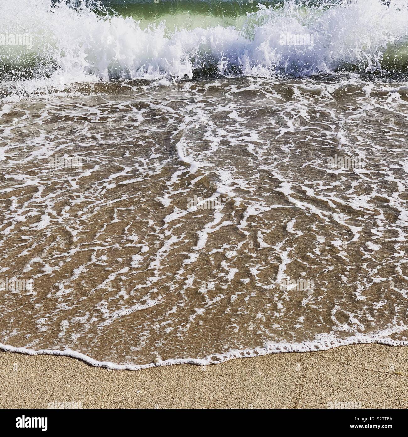 Wave crashing on a beach Stock Photo - Alamy