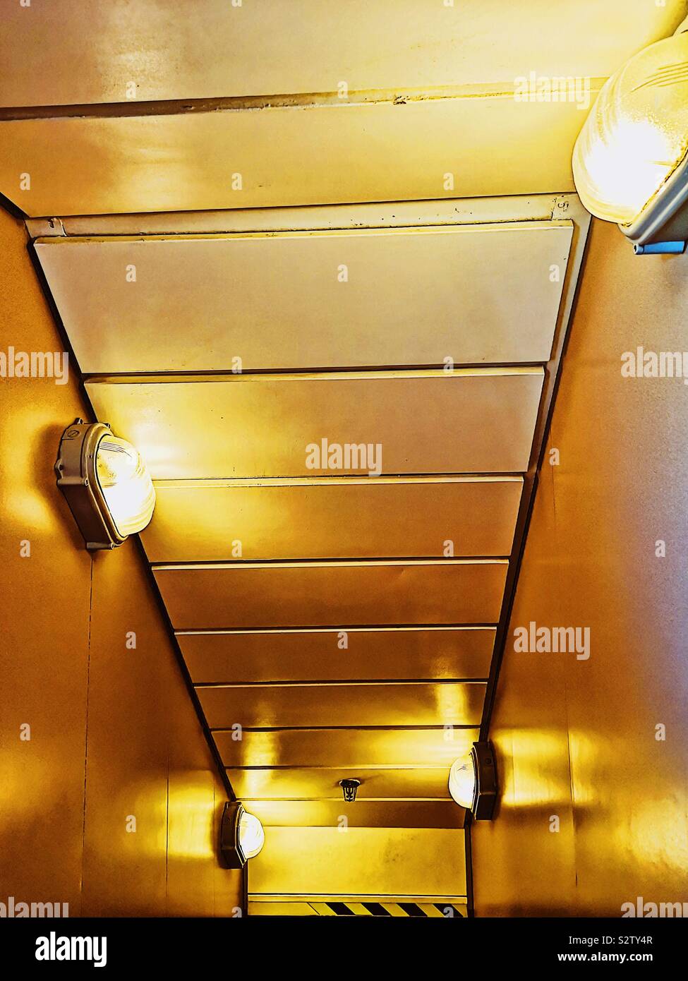 Ships passageway illuminated with bright warm yellow lighting Stock ...