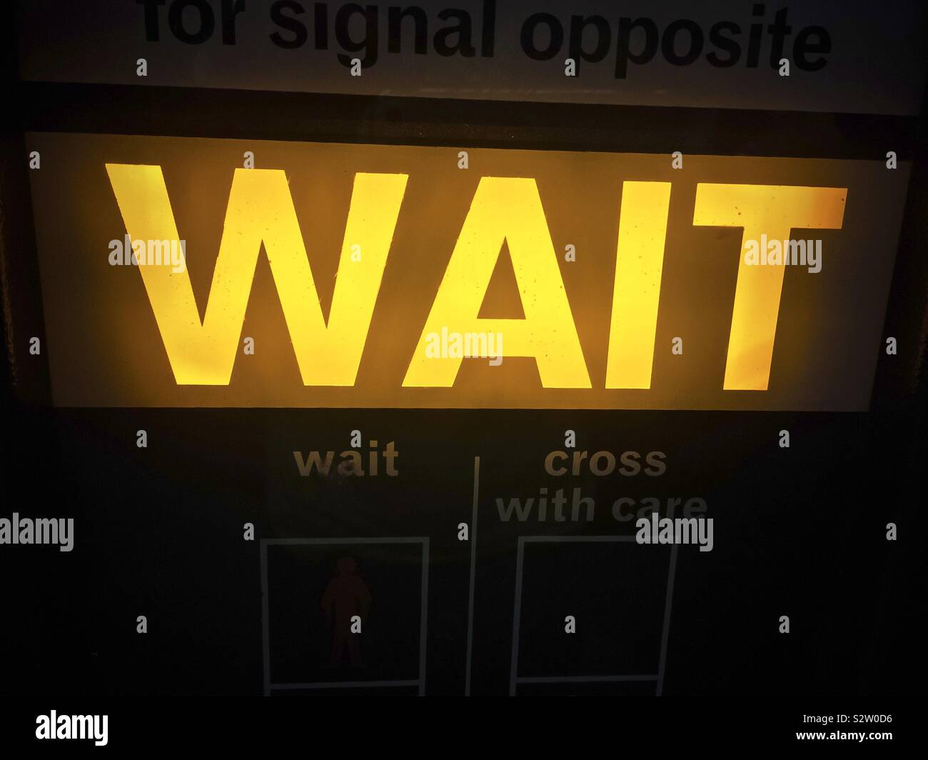 Close up of illuminate WAIT word in a pedestrian crossing in London, UK ...