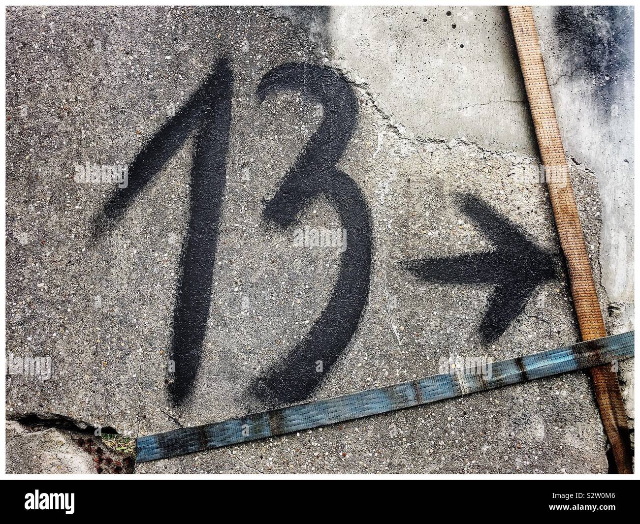 Number thirteen painted on stone wall with a arrow pointing right Stock ...