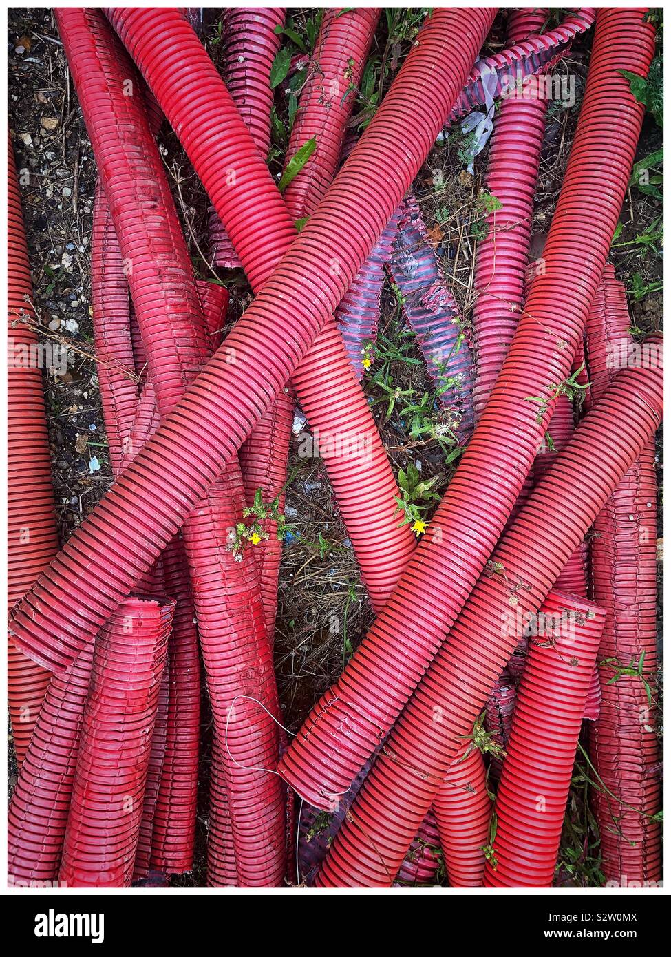 Red pipes and weeds Stock Photo - Alamy
