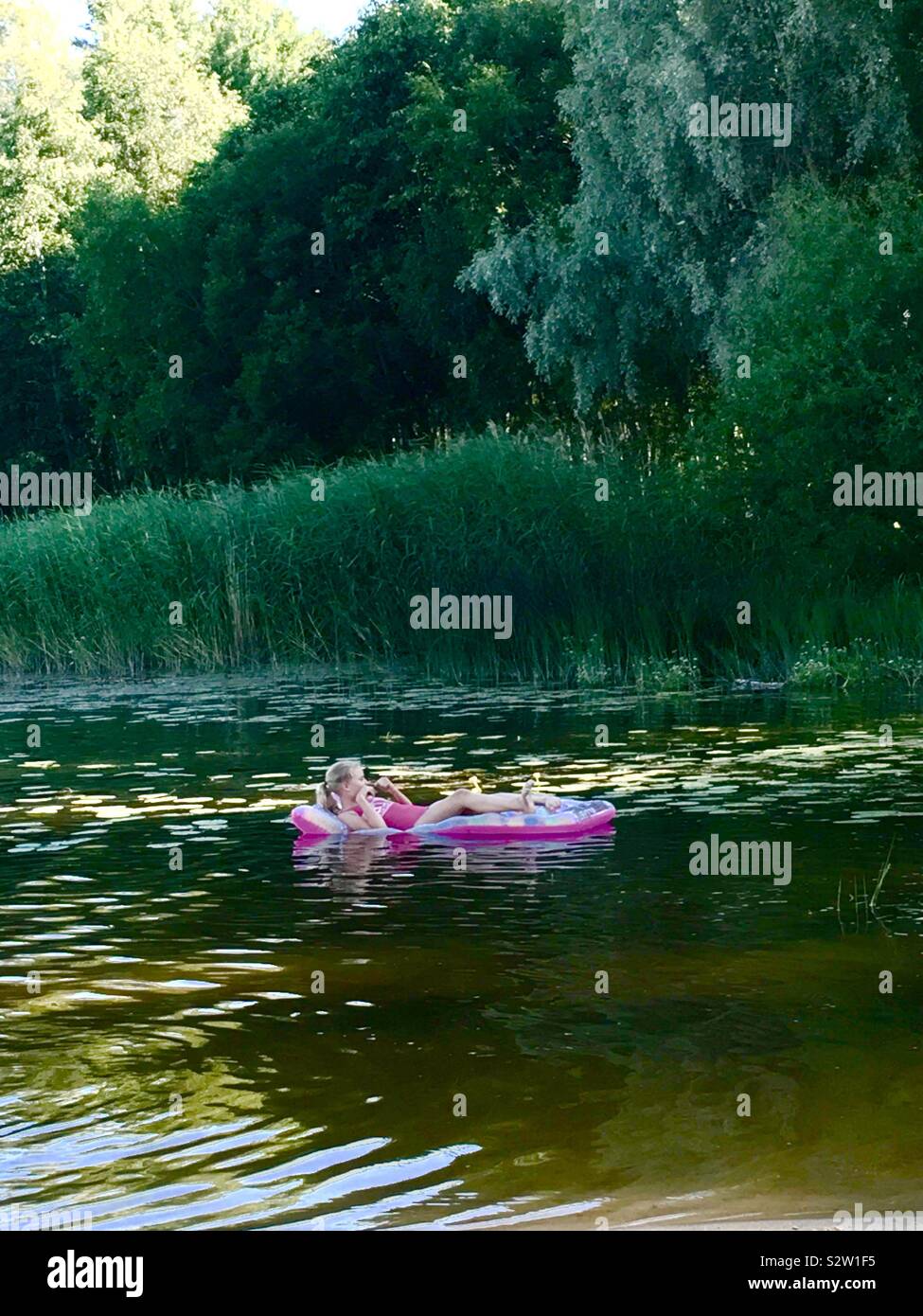Girl floating on water Stock Photo - Alamy