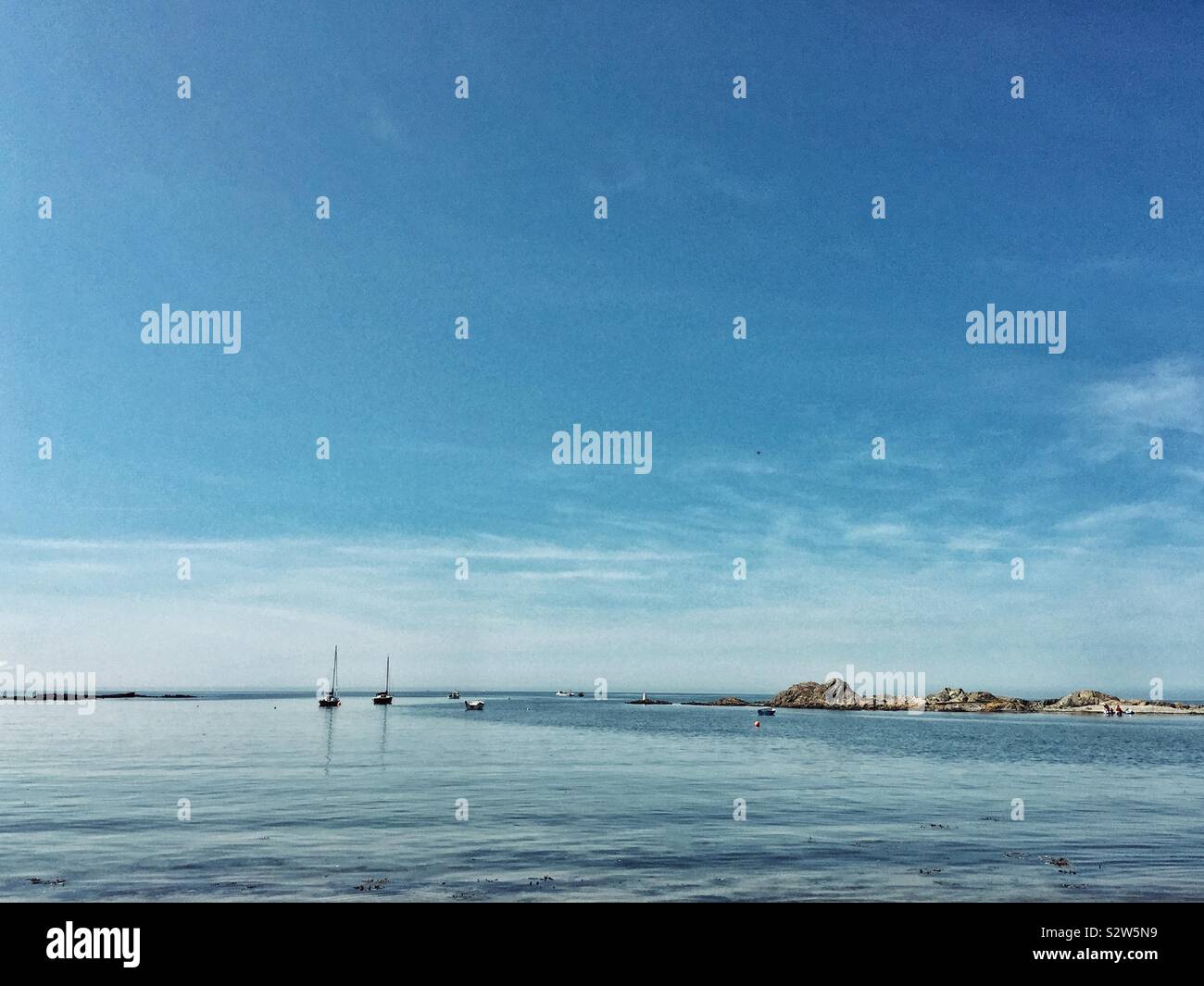 Anchored Moored sailing boats in the sea at Rhosneigr, Anglesey, North ...
