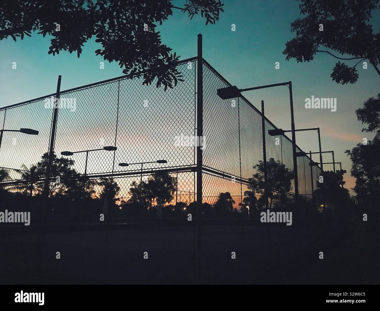 Beautiful sunset in town, a view from a tennis court Stock Photo - Alamy