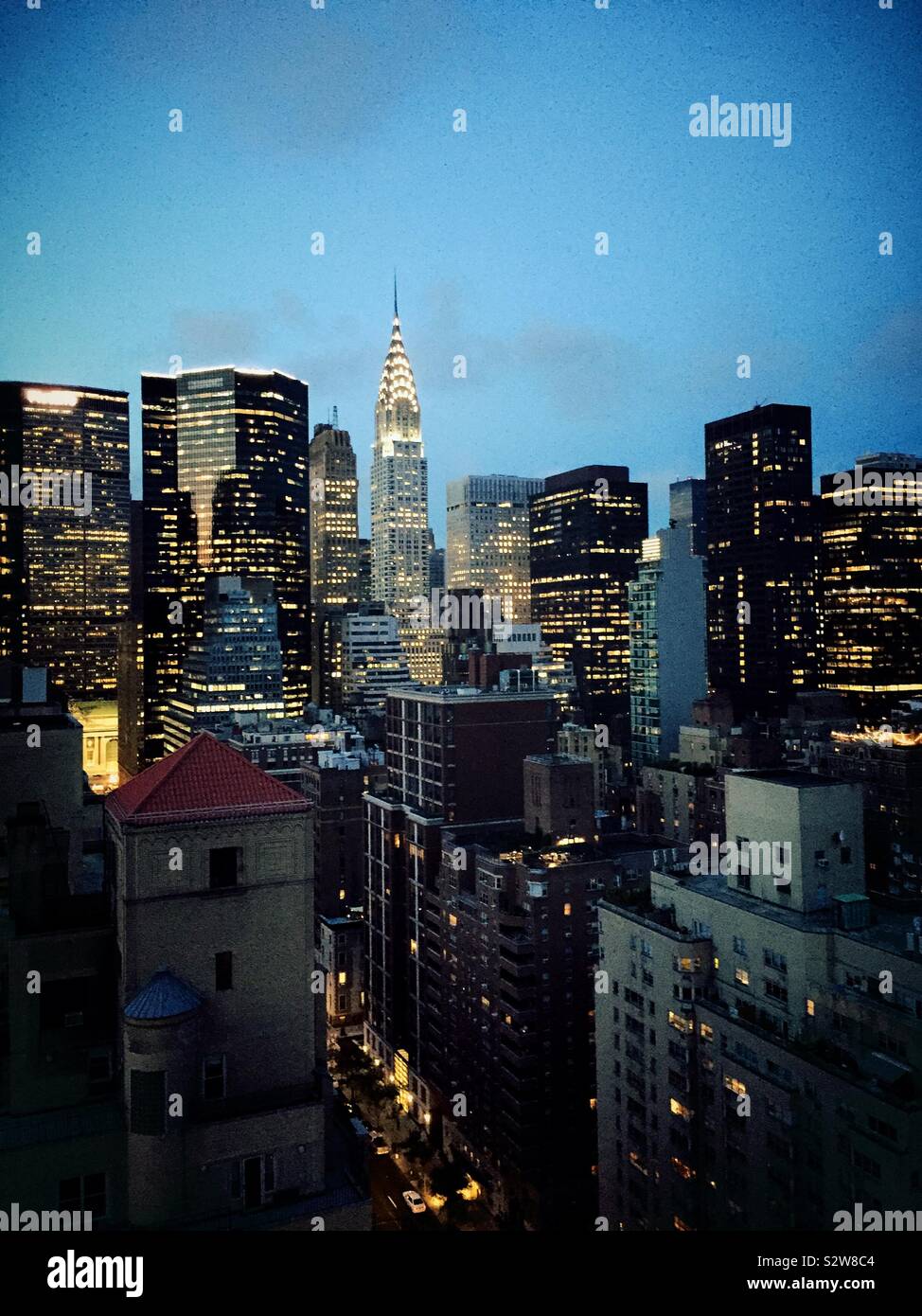 Night time vista of midtown Manhattan skyscrapers as seen from a roof ...