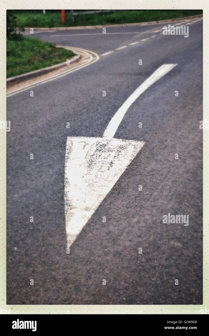 White painted directional arrow marking on road Stock Photo - Alamy