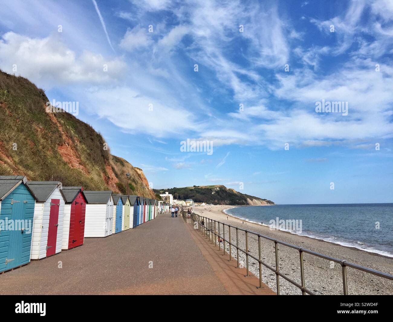 View across promenade and Beach huts at Seaton beach, South Devon, UK ...