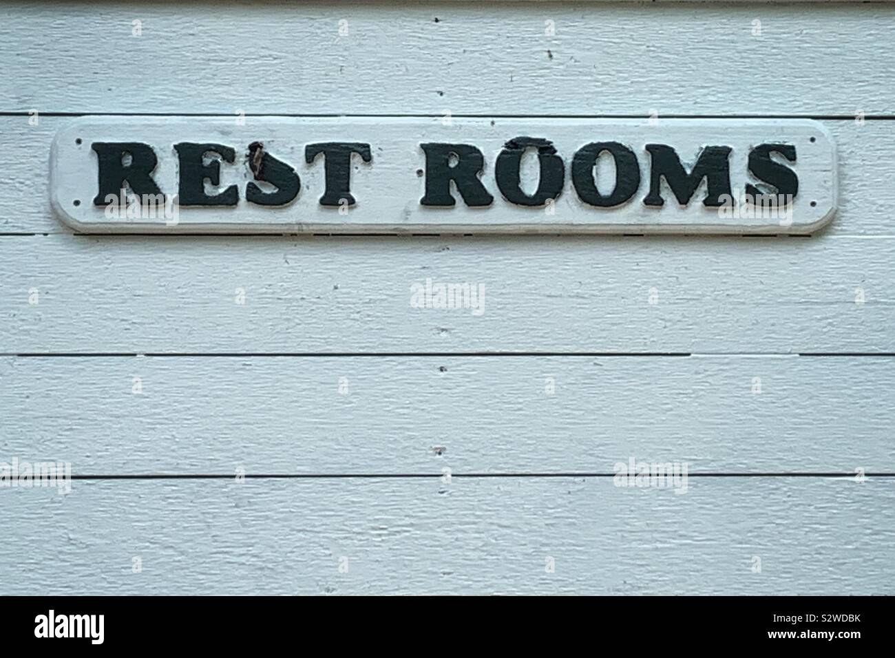 Wooden handmade rest rooms sign on a white wall Stock Photo - Alamy