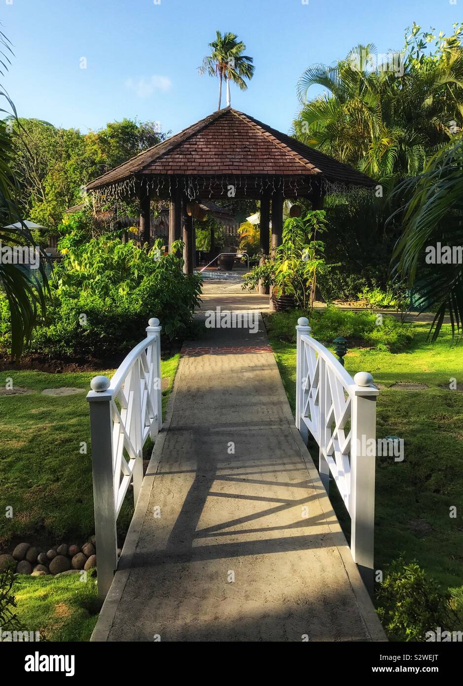 Small White Footbridge Leading To A Gazebo In a Tropical Garden At East ...