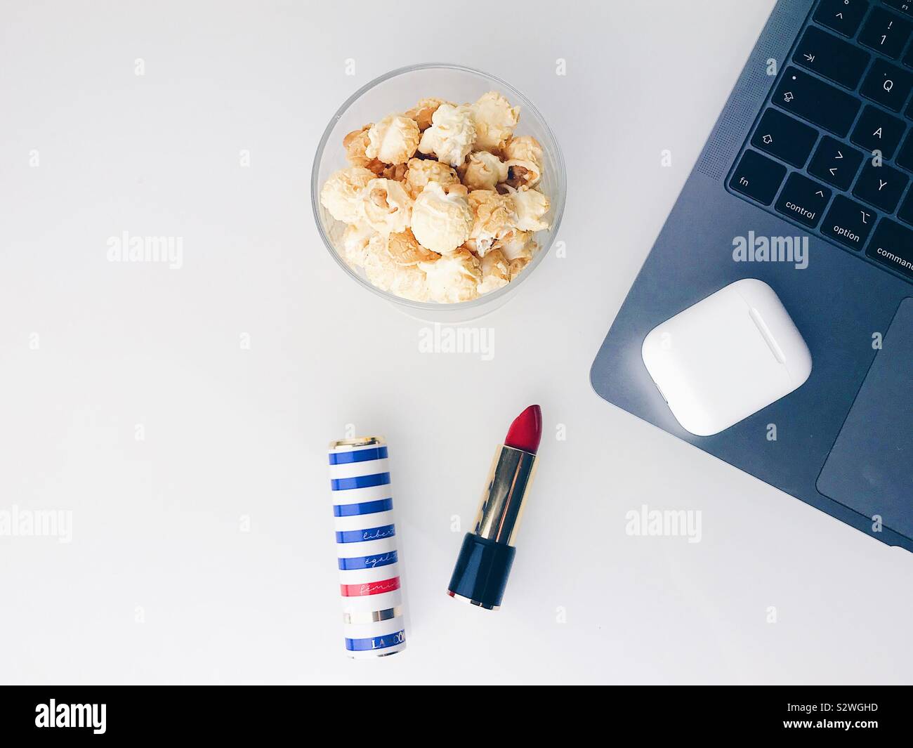 Work desk with popcorn snack, red lipstick, laptop and headphones Stock ...