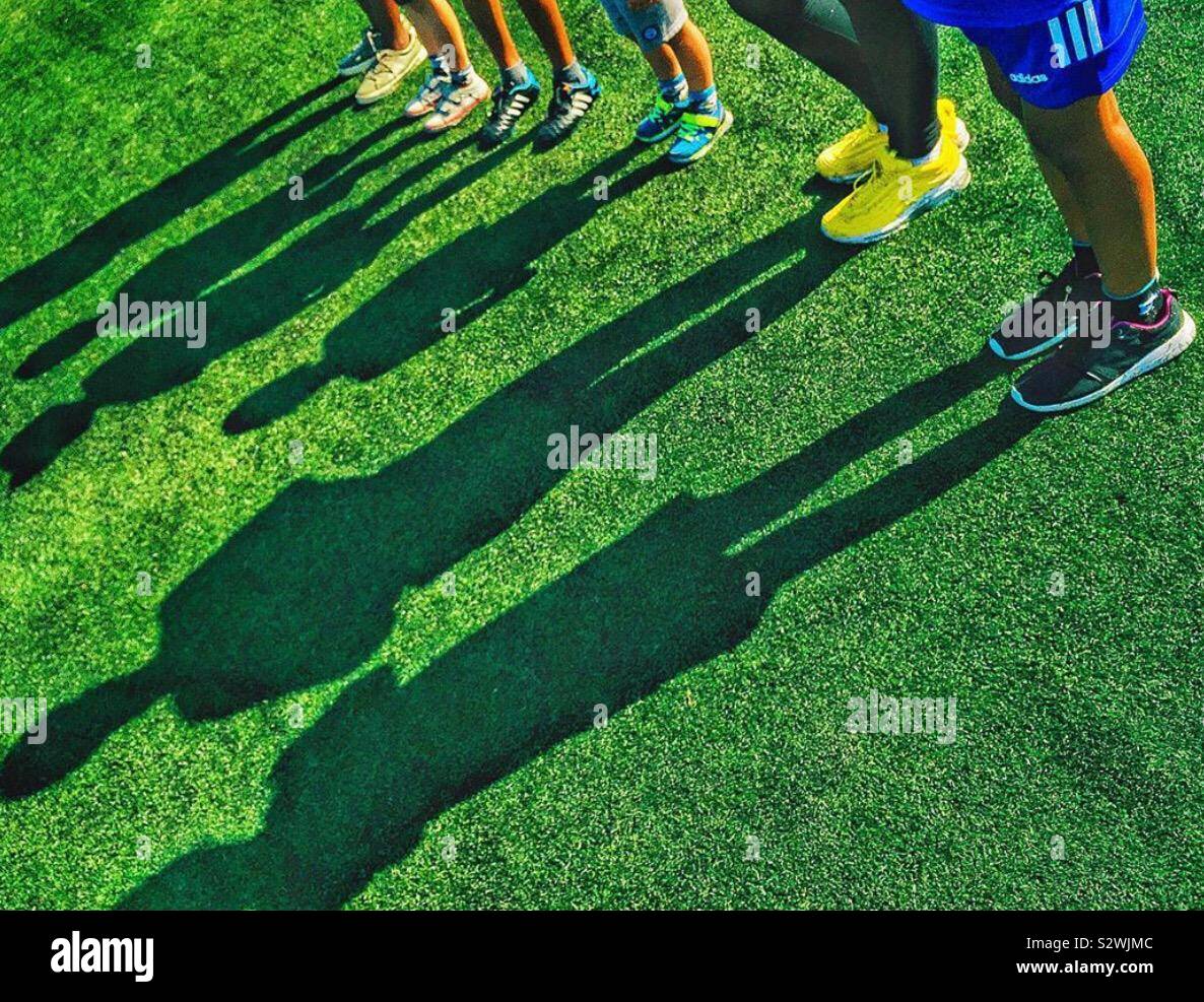 The shadows of kids playing football Stock Photo - Alamy