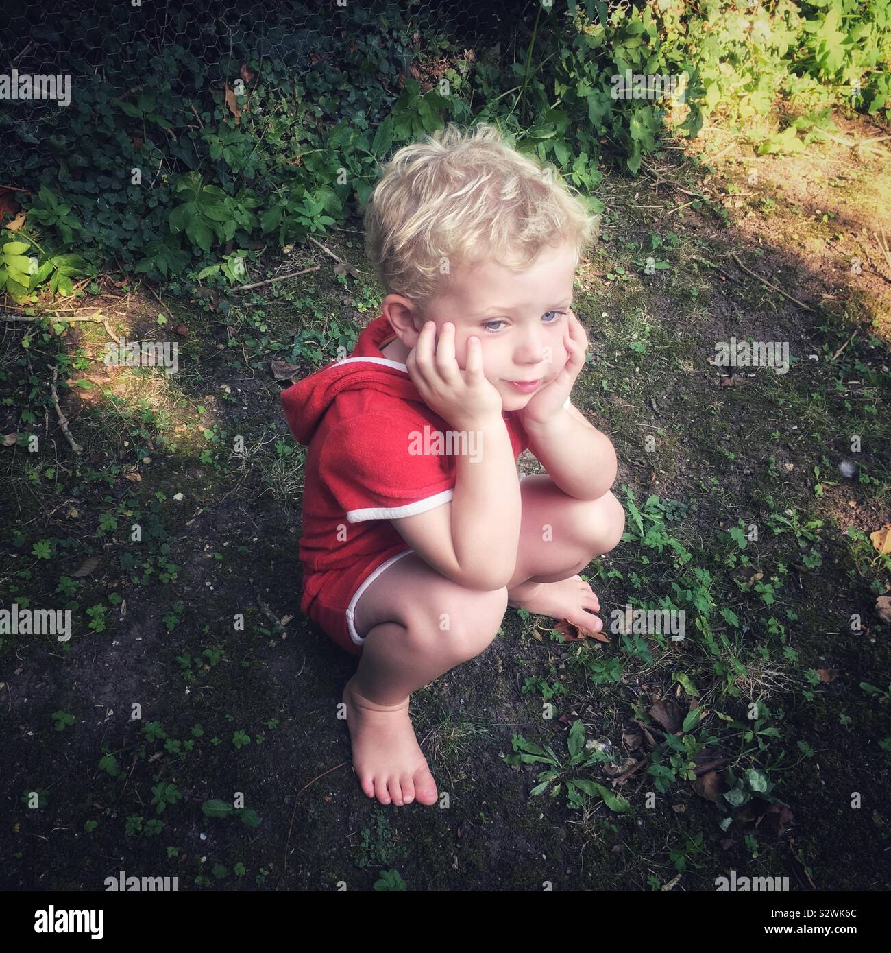 Three year old boy waiting patiently in the garden Stock Photo - Alamy