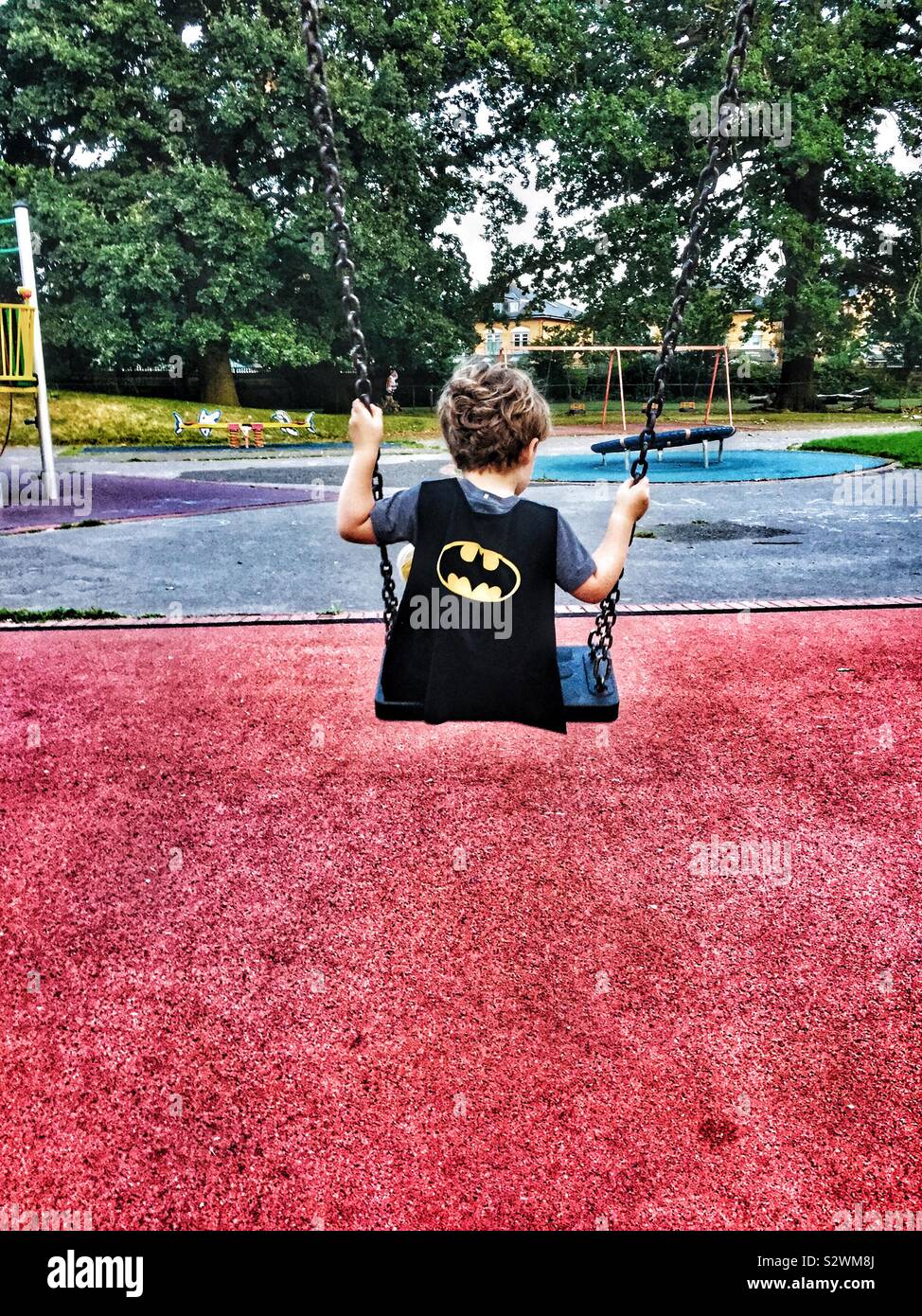 Toddler batman on swing Stock Photo - Alamy
