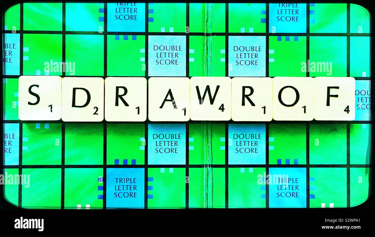 Scrabble tiles spelling out ‘’Forwards’ backwards on the green and blue ...