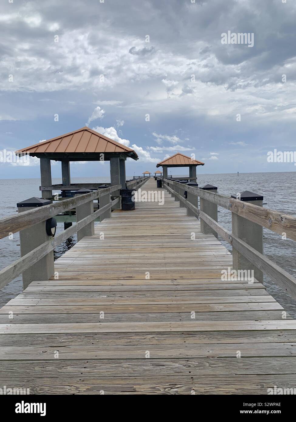 Long wooden pier over the Gulf of Mexico with covered seating areas ...