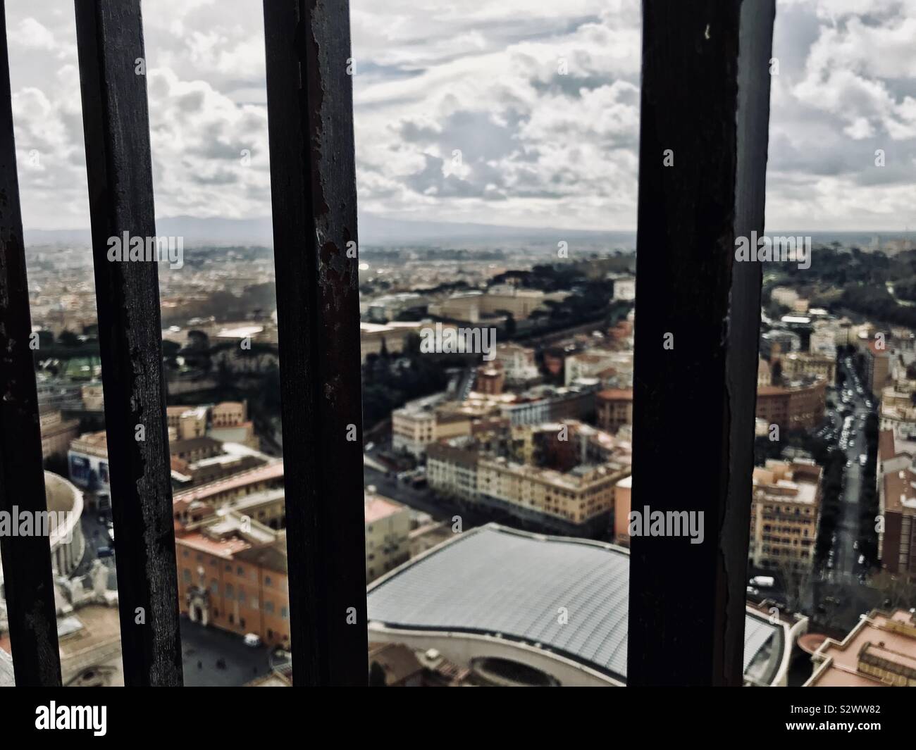 City of Rome viewed through bars in the window on the dome of St. Peter ...