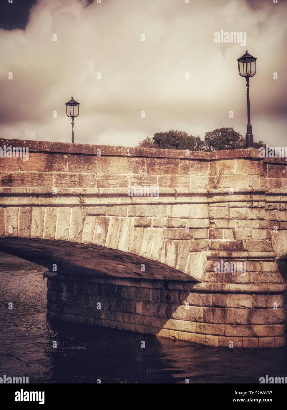 Old bridge over river with lamp posts Stock Photo - Alamy