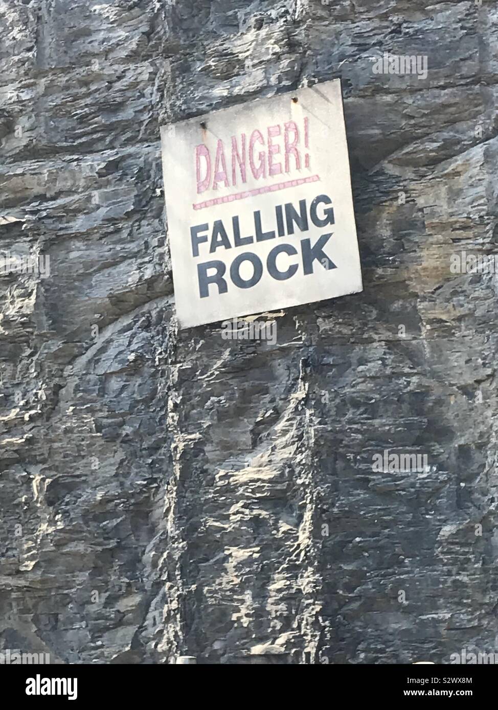 Falling rock sign on cliff Stock Photo - Alamy
