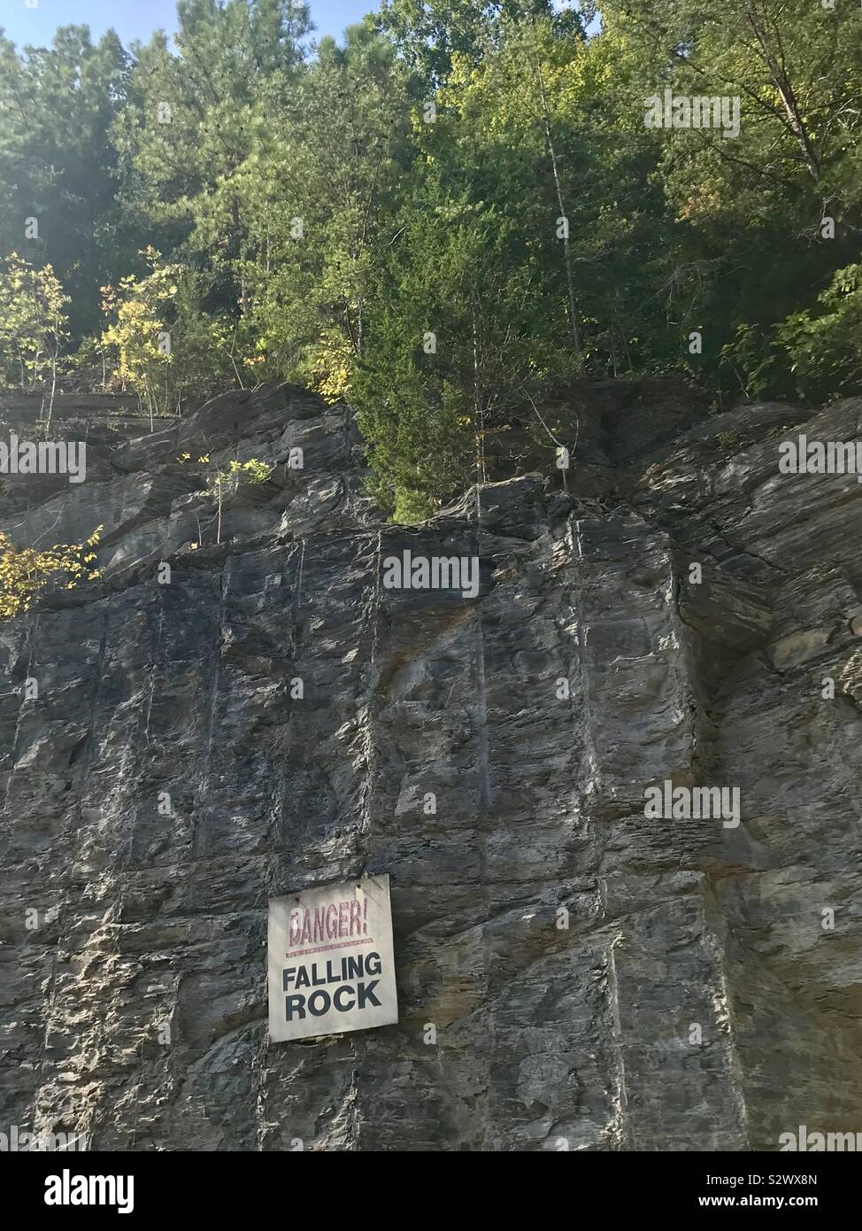 Cliff with falling rock sign Stock Photo - Alamy