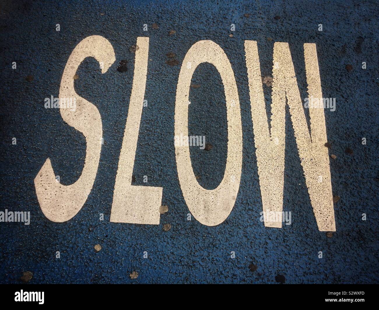 Slow sign painted in the road, UK Stock Photo - Alamy