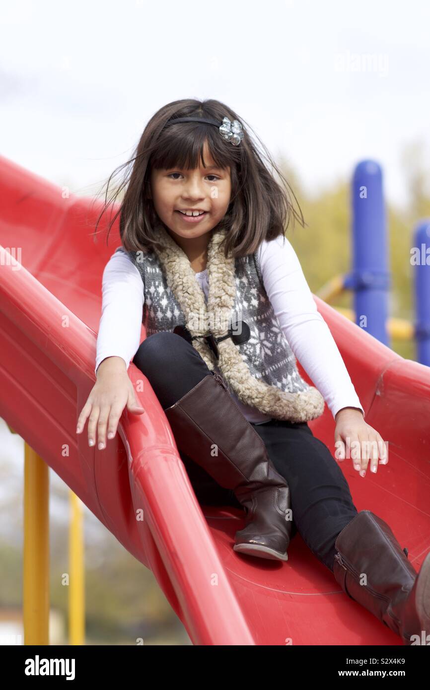 Young girl playing in the playground with fall clothing Stock Photo - Alamy