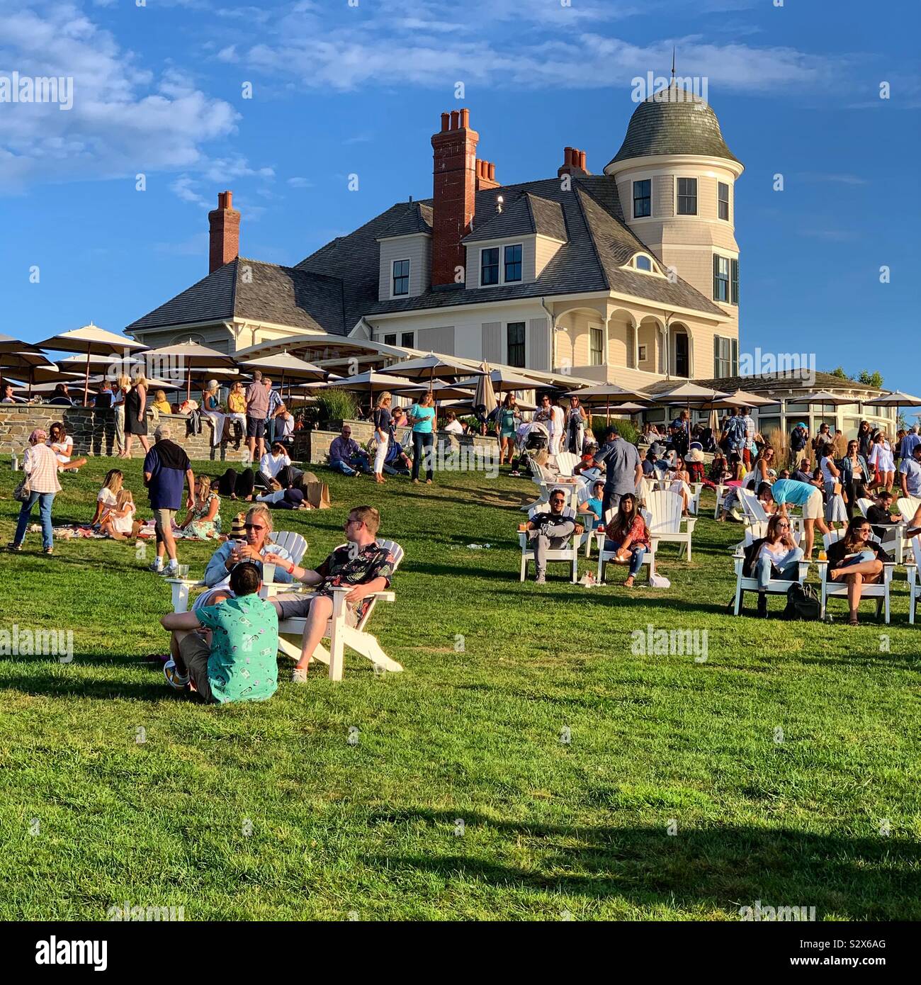 People gathering on the lawn in the late afternoon at Castle Hill Inn ...