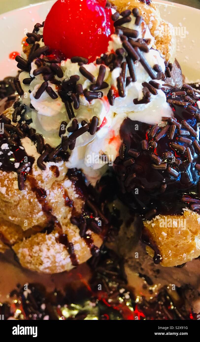 Huge sundae with whipped cream, chocolate ice cream, and cherry with ...