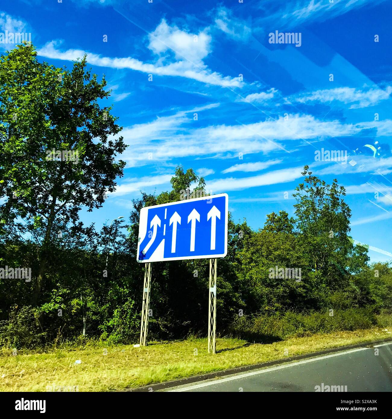 Slip road merging sign on grass verge of roadside Stock Photo - Alamy