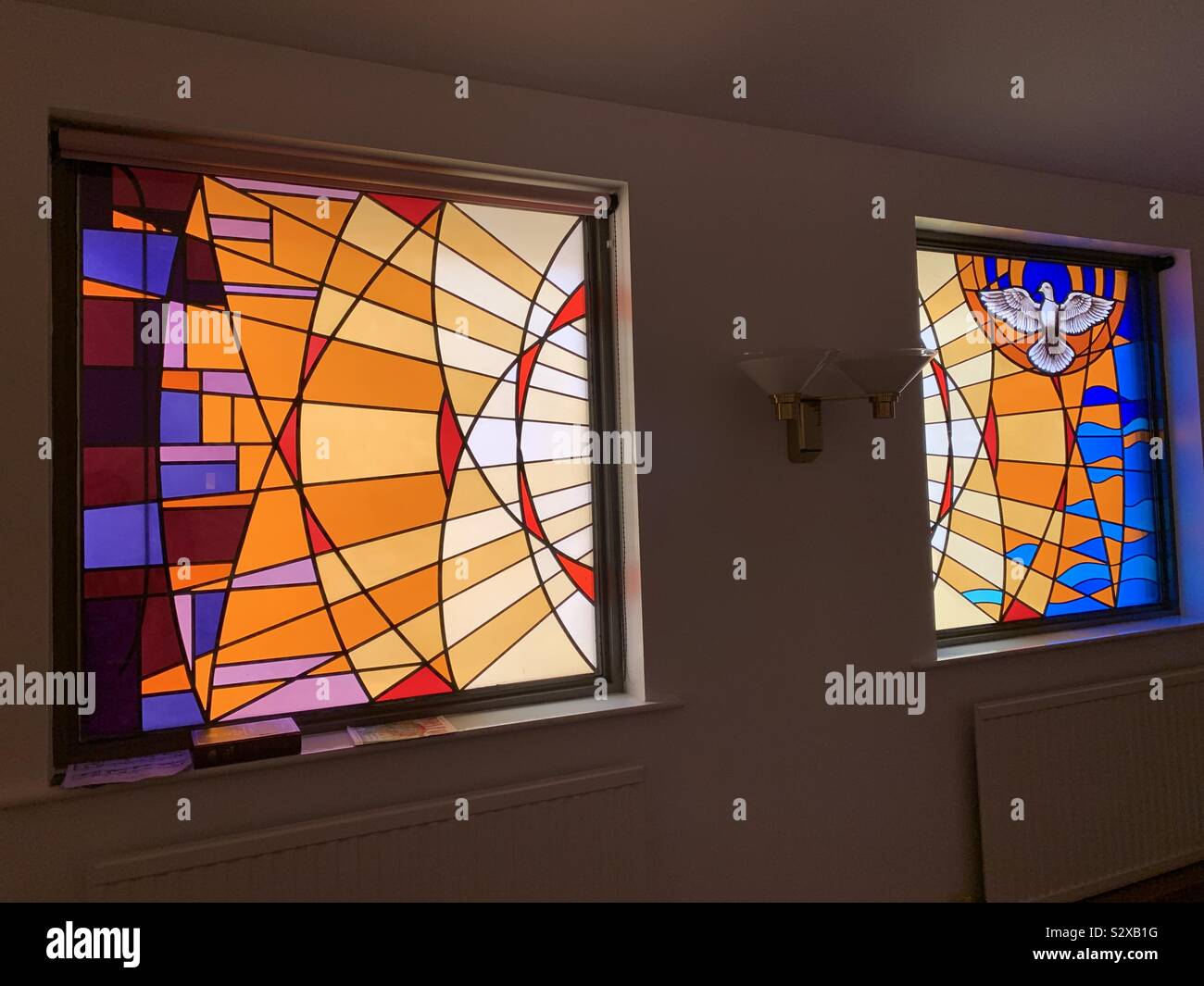 Two square stained glass windows with a bird Stock Photo - Alamy