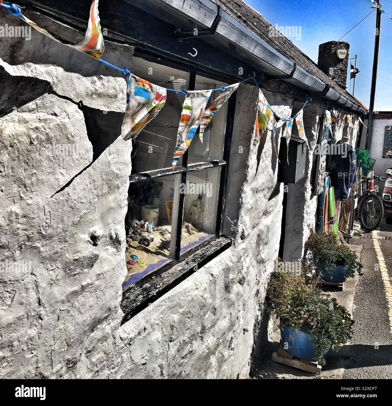White Washed Stone Walled village Shop with bunting tied along the ...