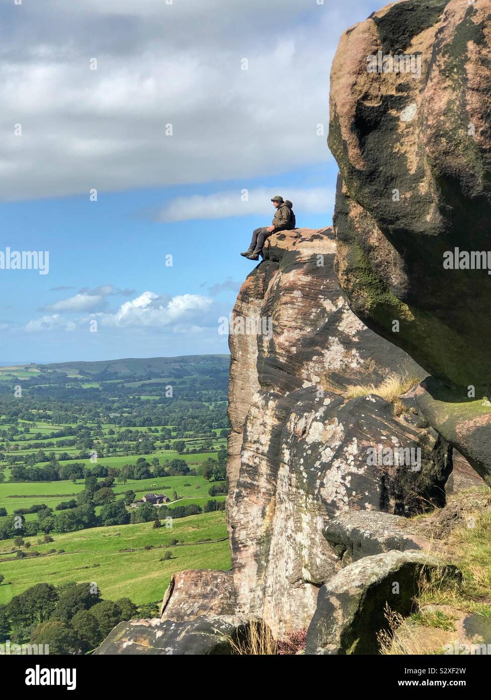 Male hiker sitting on a sandstone rock formations- Hen Cloud, Peak ...