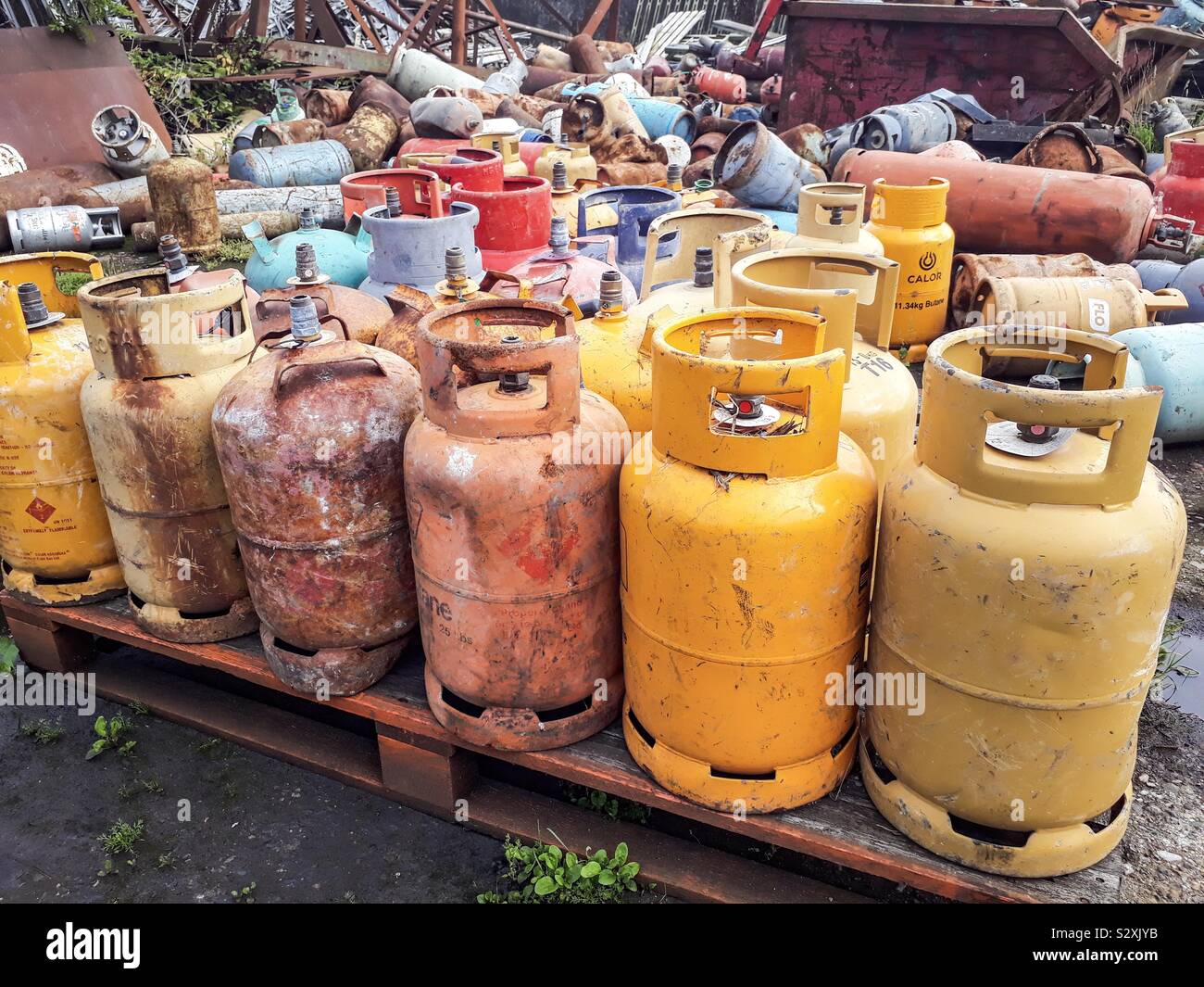 Old, rusty gas bottles on a pallet at scrapyard Stock Photo - Alamy
