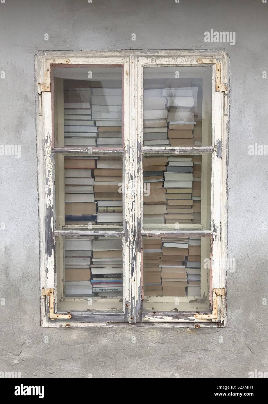 Stacked books in rustic window frame Stock Photo - Alamy